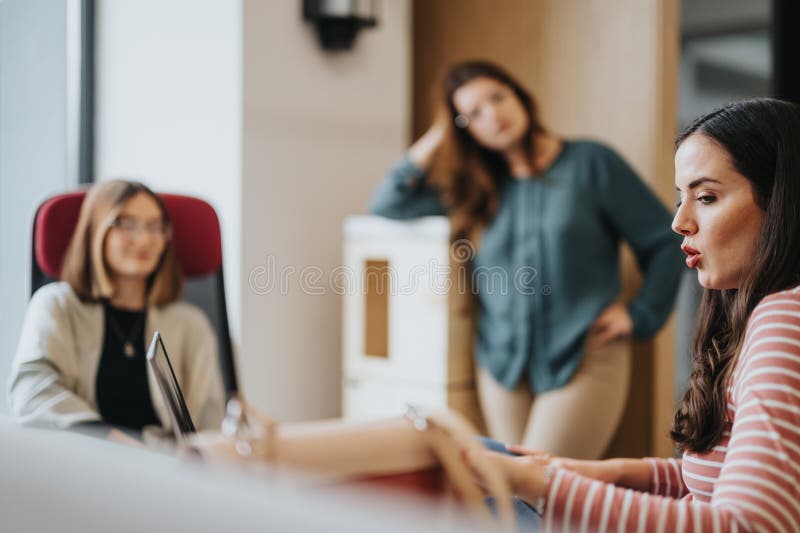 Three Focused Female Colleagues Collaborate in a Modern Office Setting ...