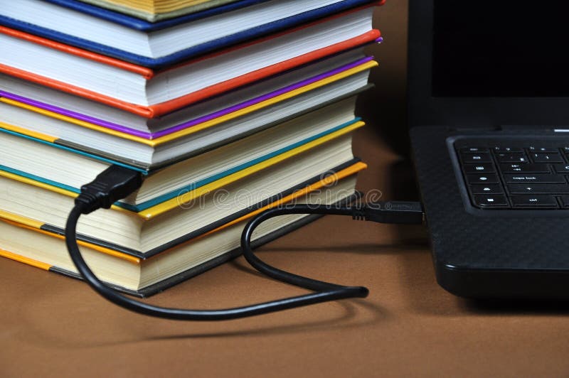 A Laptop and a Stack of Books Connected by a Cable Stock Image - Image ...