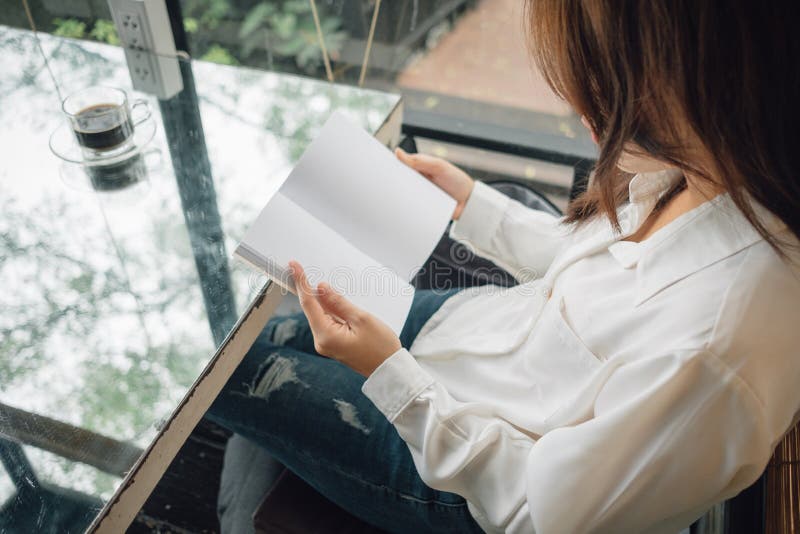 Young Woman Sitting Alone and Reading Book in Restaurant with Co Foto ...