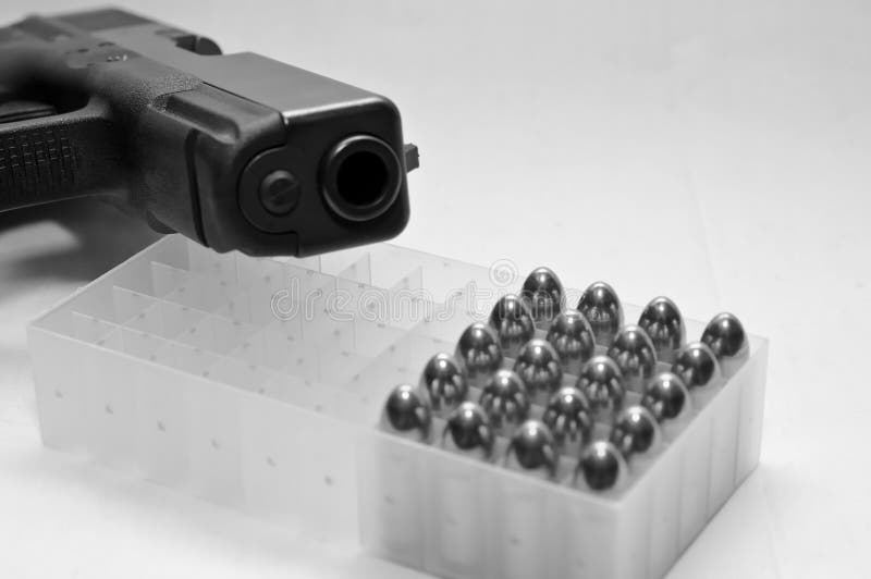 A Black Semiautomatic 9mm Pistol Laying on Top of a Plastic Bullet Case ...