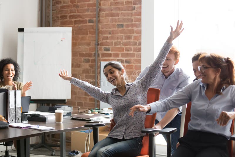 Excited Diverse Employees Have Fun Riding Chairs in Office Stock ...