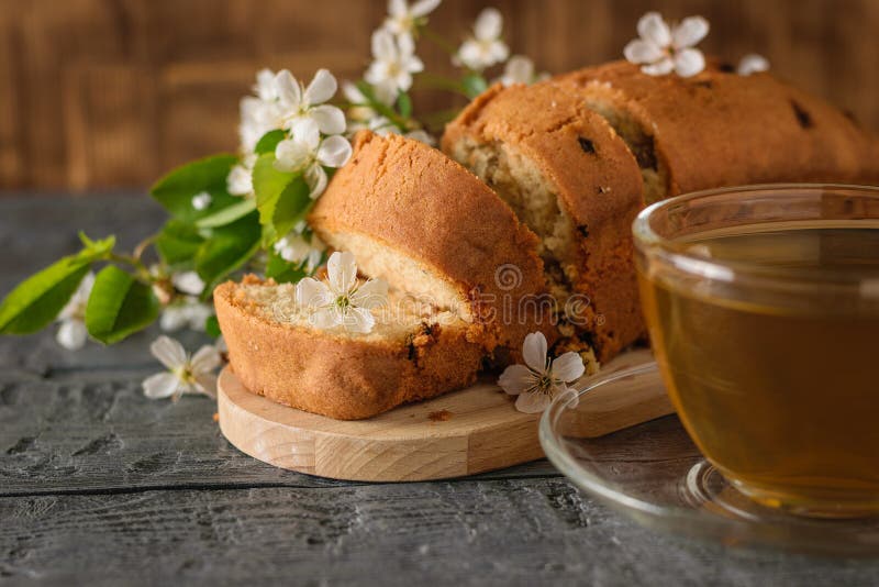 Sliced Cake with Raisins, Tea and a Branch with Flowers on the Table ...