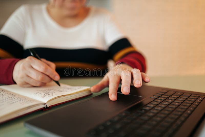 E-Student in Action Close-Up of a Woman Taking Notes on a Notebook ...