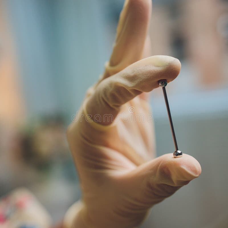 Ear Jewelry, Piercing in Hand with a Disposable Glove. Stock Image ...