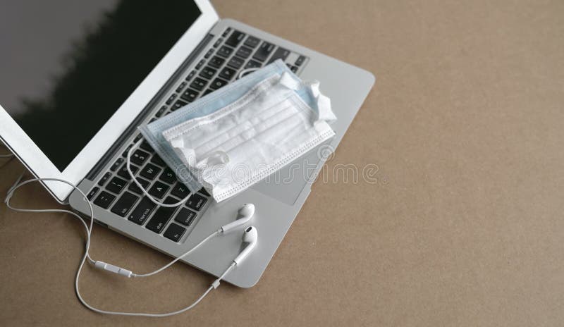 Ear Phones on Top of Computer Laptop with Face Mask Stock Image - Image ...