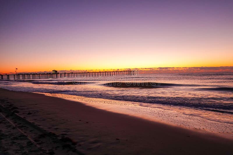 Early Morning Dramatic Sunrise Over the Ocean and Long Pier Stock Photo ...