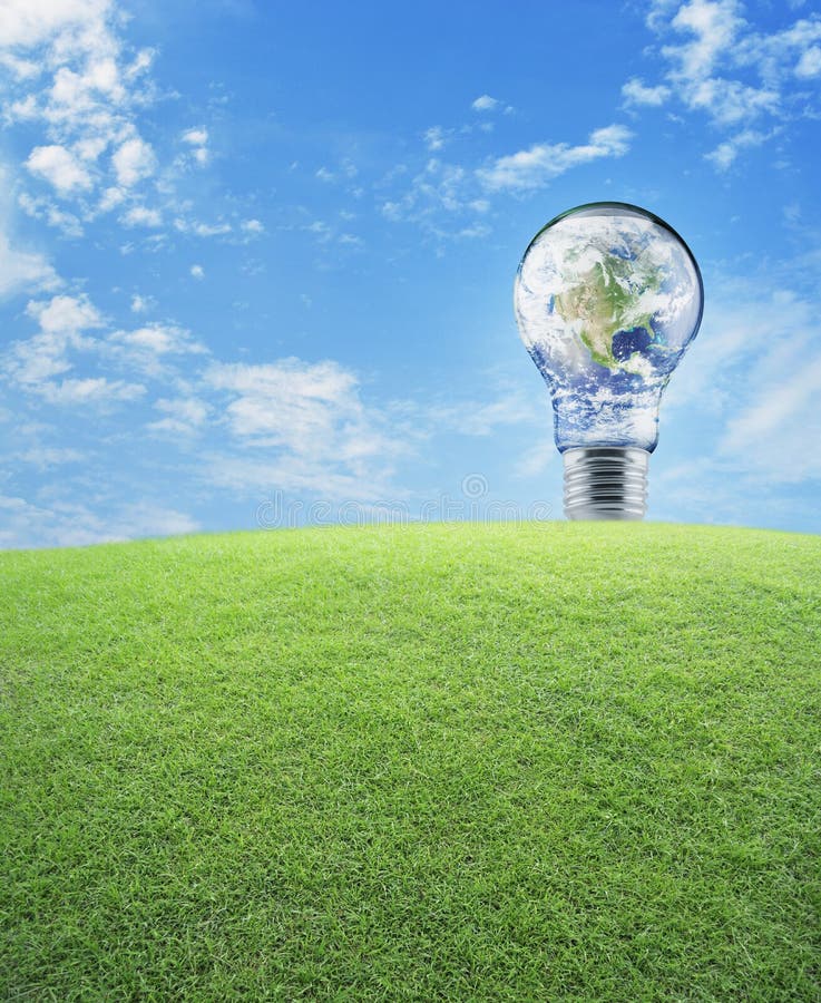 Earth Globe in Light Bulb with Green Grass Field Over Blue Sky, Stock ...
