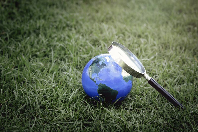 Earth Globe with Magnifying Glass on Green Grass, Discovering New ... Earth Globe with Magnifying Glass on Green Grass, Discovering New ...