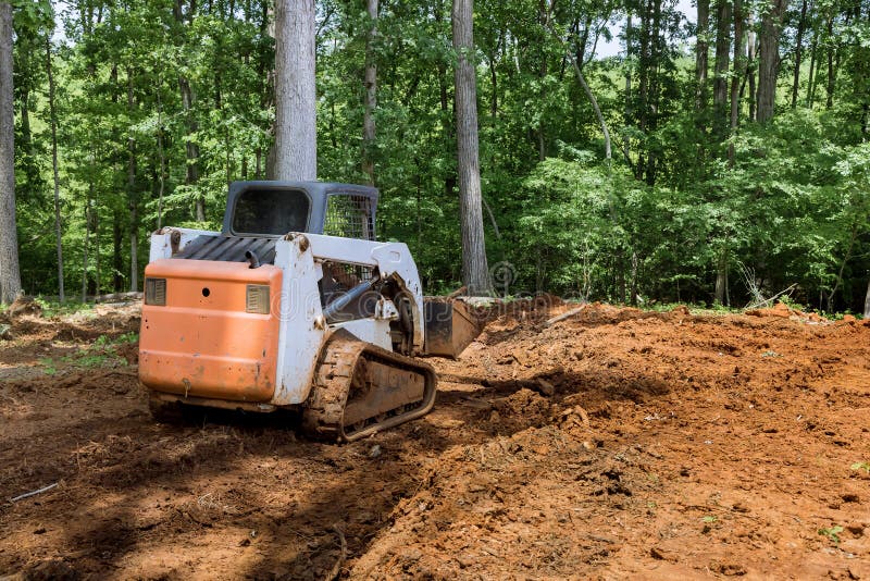An Earthmoving Tractor is Leveling Ground during a Construction Project ...