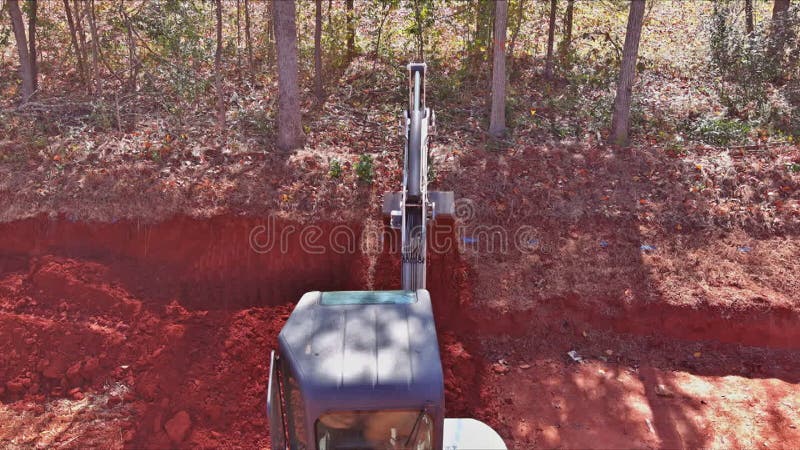 An Earthmoving Worker Digging the Ground at a Construction Site with a ...