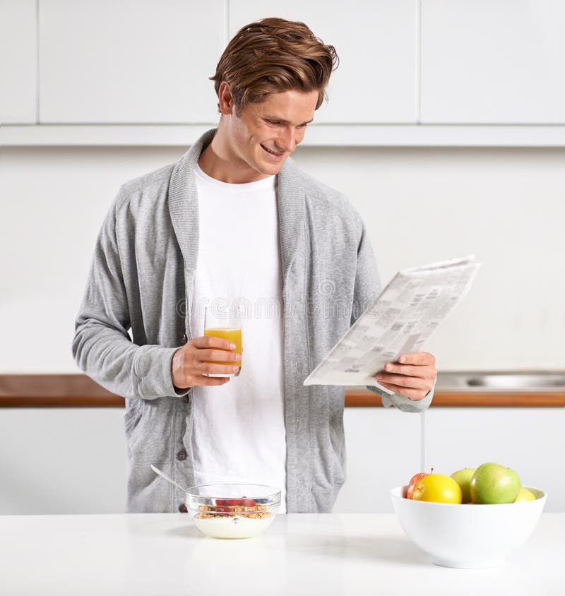Easing into the Day. a Handsome Young Man Reading the Newspaper during ...