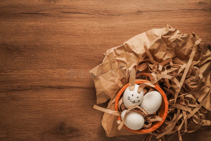 Easter, Decorated Egg Like a Rabbit Face and White Eggs on Brown Paper ...