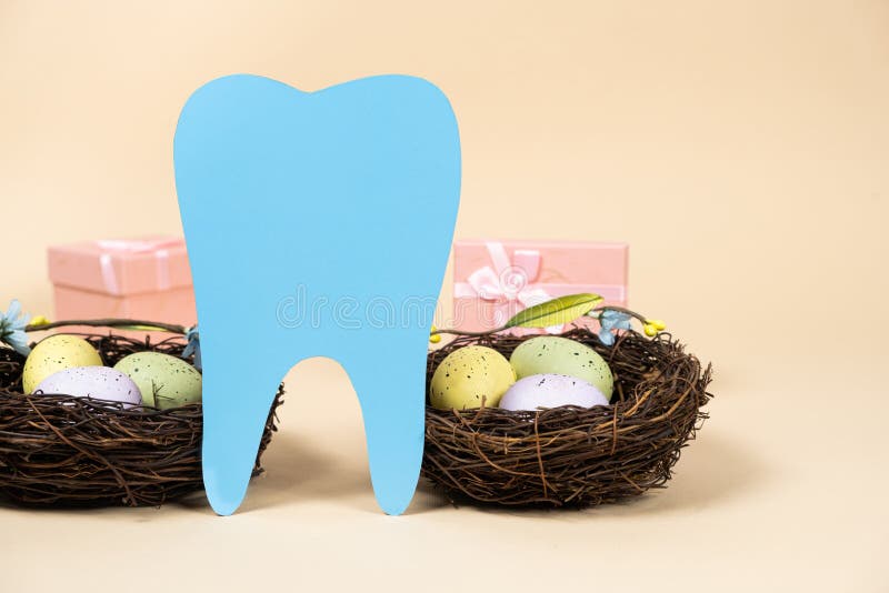 Easter Dentistry. Blue Tooth and Painted Eggs in Nests on a Beige ...
