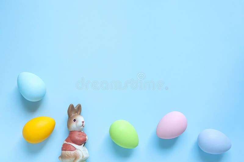 Easter Eggs Painted in Pastel Colors and Rabbit Figures on a Light Blue ...