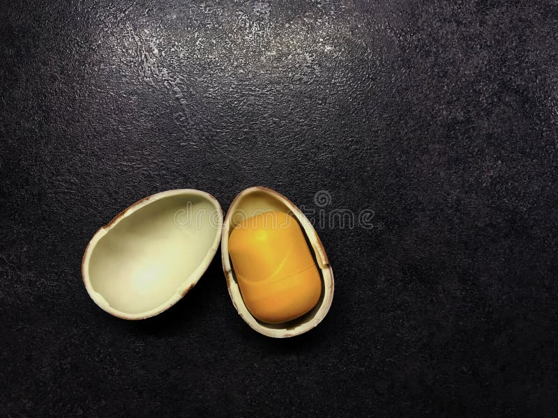 Easter Open Chocolate Kinder Egg with a Yellow Core on a Black Table ...