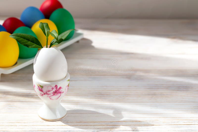 White Egg with Green Sprout in a Stand and Easter Eggs Stock Image ...