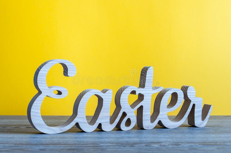 Easter - Word Carved of Wood at Yellow Background. Holiday Concept ...