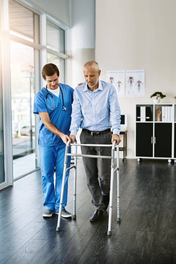 Easy Does it. a Male Nurse Assisting a Senior Patient with a Walker ...