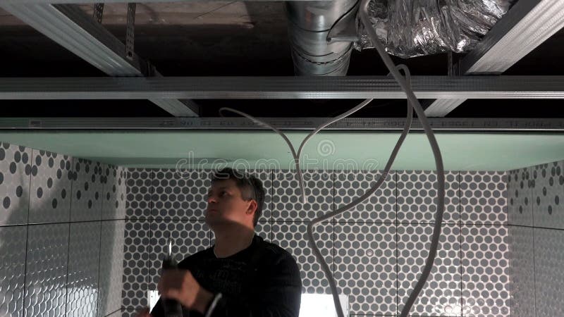 Easy Fixing Gypsum Ceiling. Worker Screws Sheet of Plasterboard To ...