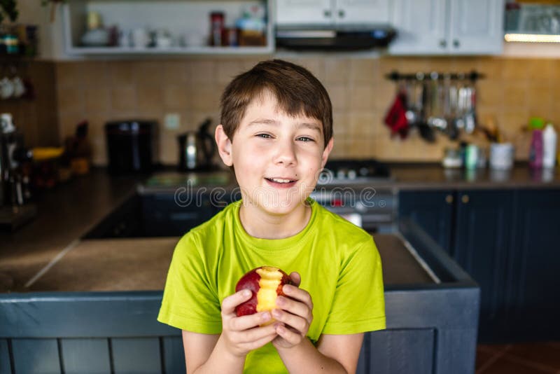 Boy eating apple stock image. Image of happy, cute, fruit - 186528737