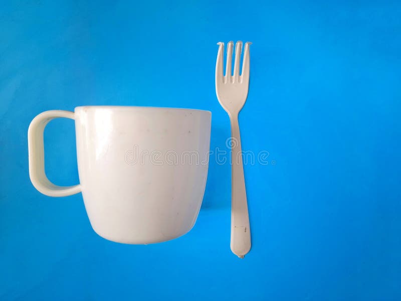 White Cup and Plastic Fork with a Blue Background Stock Image - Image ...