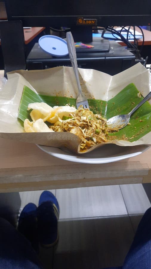 Eating Traditional Pecel Rice from Java in Front of a Computer during ...
