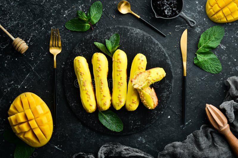 Eclair with Mango Cream. Mango Dessert on a Black Stone Plate. Top View ...