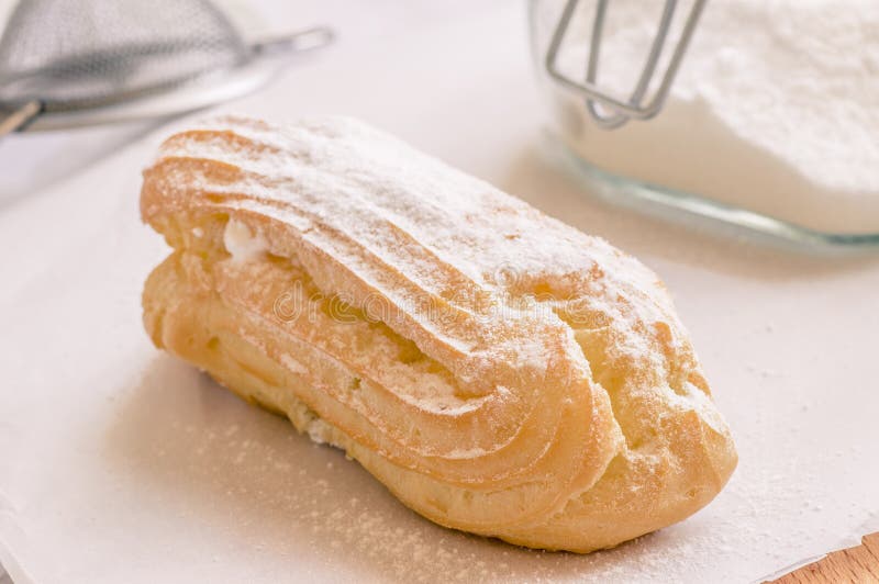 Eclair in powdered sugar stock photo. Image of cake, pastry - 54303930