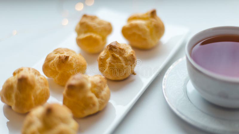 Eclairs and a cup of tea stock image. Image of eclairs - 72994297