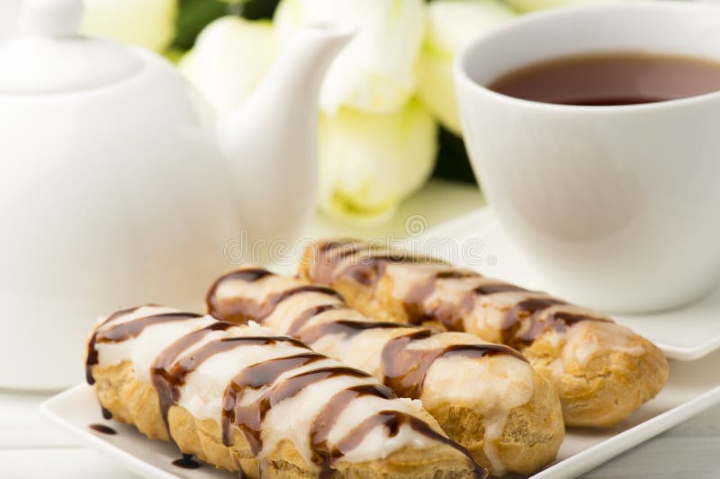 Eclairs and Cup of Tea on Wooden Table. Stock Photo - Image of pastry ...