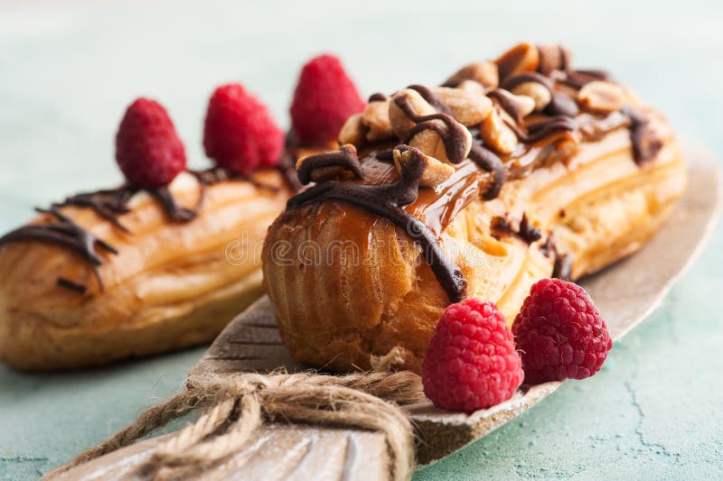 Eclairs with Peanuts, Chocolate Icing and Raspberries Stock Image ...