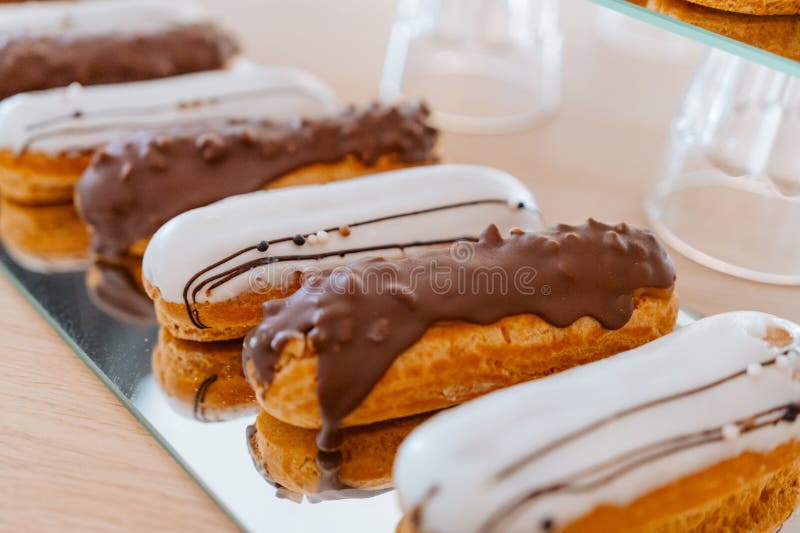 Eclairs with White and Chocolate Icing are Laid Out in a Row on a ...