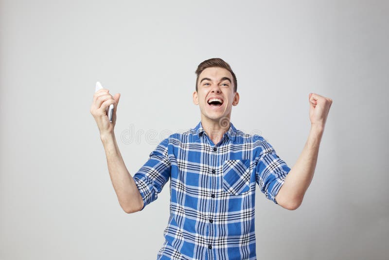 Ecstatic Full of Energy Guy Dressed in a Plaid Shirt Keeps Mobile Phone ...