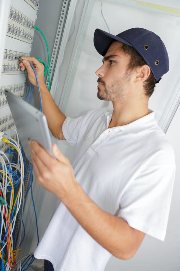 Focused Electrician Applying Safety Procedure while Working on ...