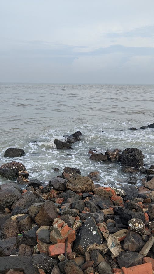 The Edge of the Beach with Waves Breaking between Many Rocks Stock ...