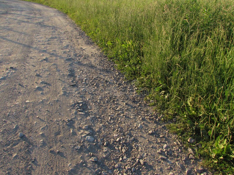 The Edge of the Roadside of a Light Rocky Forest Road and Green Summer ...