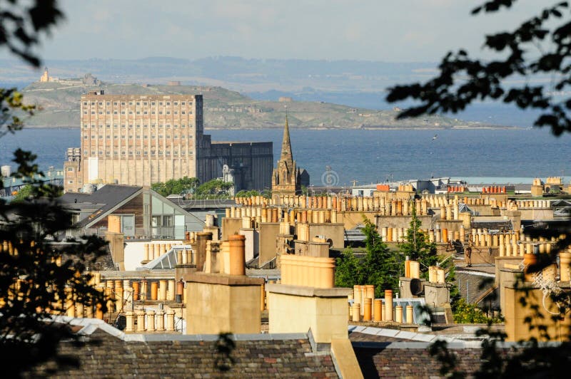 Edinburgh Rooftops with Chimneys and Scenic Coastline in the Background ...