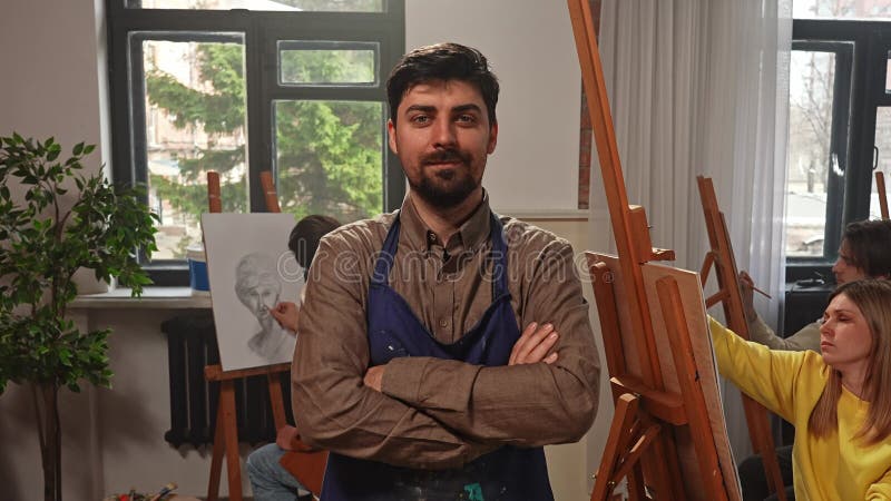 Man Art Teacher in Apron Posing in Front of Group of People Drawing at ...