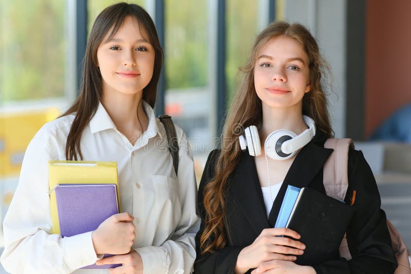 Education. Two Clever Modern Students in Black and White Uniform Study in a Library Sitting at a ...