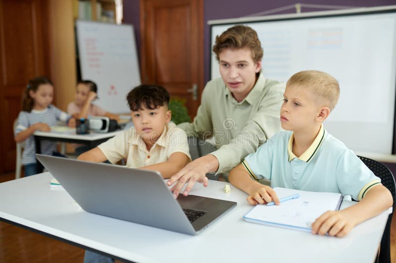 Educator Guiding Students in Classroom with Laptop Stock Image - Image ...