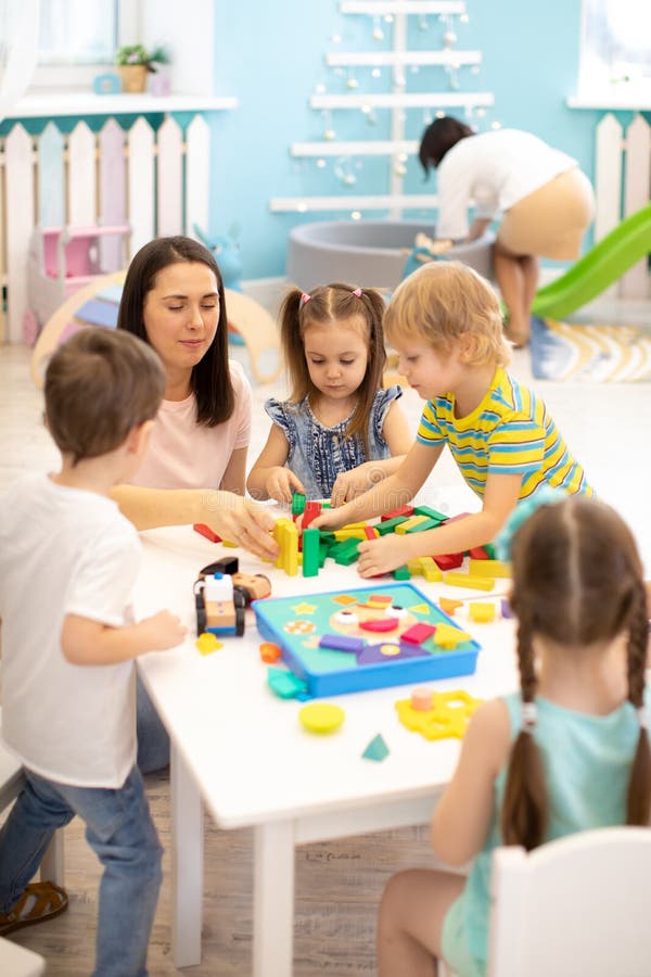 Educator Helping Kids Playing with Block Constructor in Daycare Stock ...