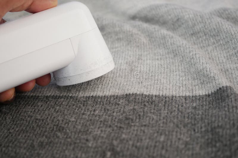 Efficient Fabric Care with White Lint Remover on Grey Sweater Stock ...
