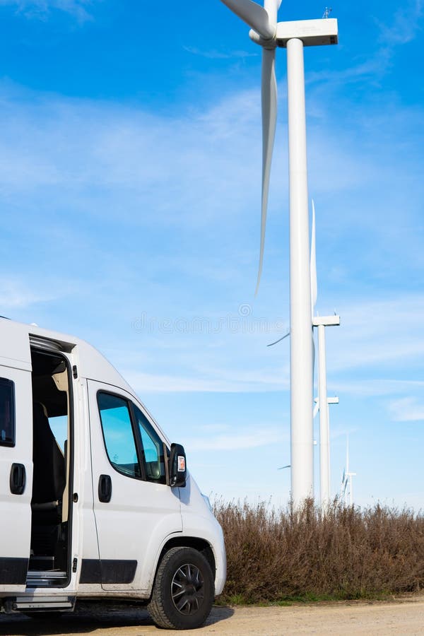 Efficient Mobile Workstation: White Van Parked by Wind Turbines in ...