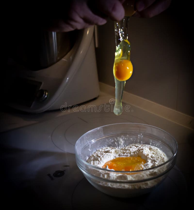 Egg falling into the flour editorial photography. Image of bakery ...