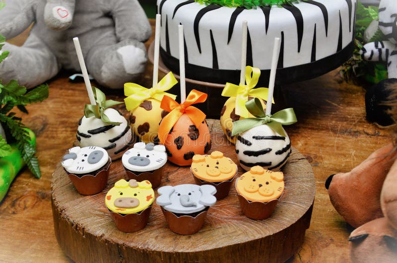 Egg-shaped Candy Apple and Animal Cupcakes on Tree Trunk Slice ...