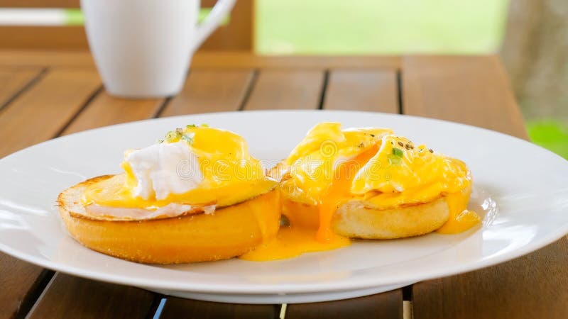 Eggs Benedict Dish with Hollandaise Sauce Cutting with Fork and Knife ...