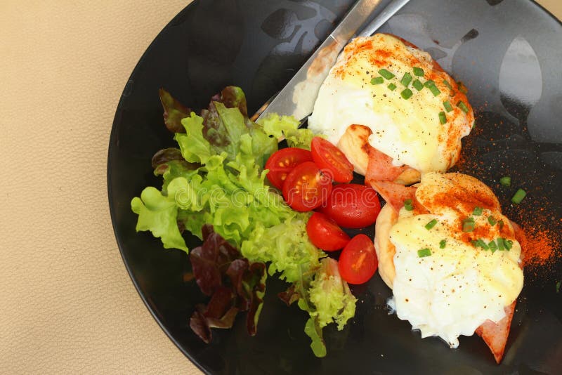 Eggs Benedict ,vegetable ,eggs on a Black Plate. Stock Photo - Image of ...