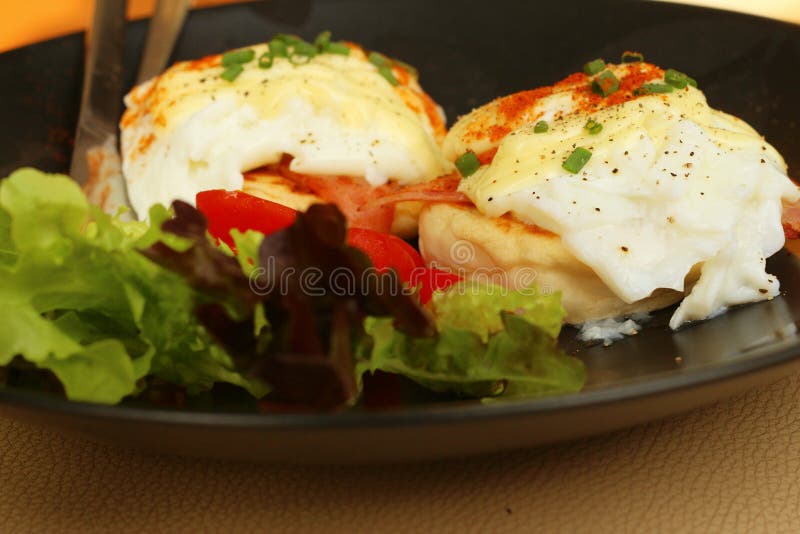 Eggs Benedict ,vegetable ,eggs on a Black Plate. Stock Photo - Image of ...