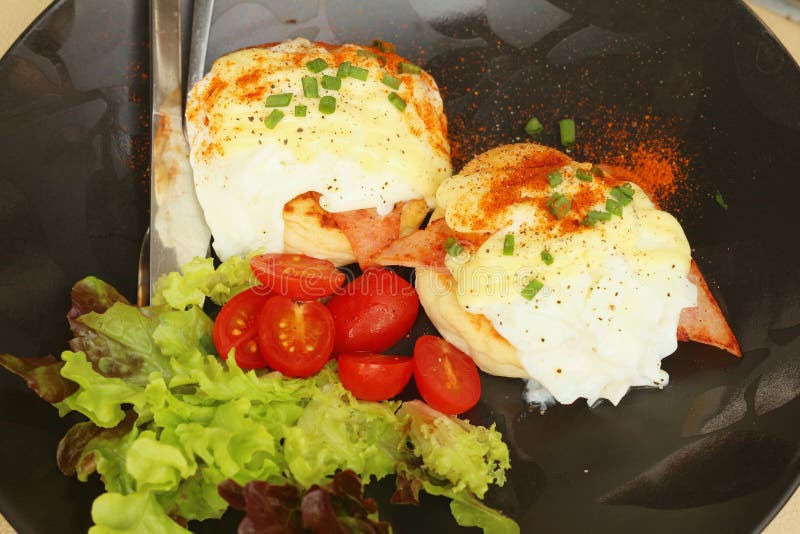 Eggs Benedict ,vegetable ,eggs on a Black Plate. Stock Photo - Image of ...