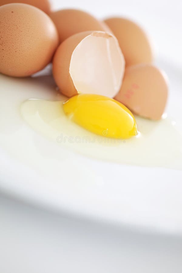 One Broken Egg in the Foreground on a Plate Stock Photo - Image of ...